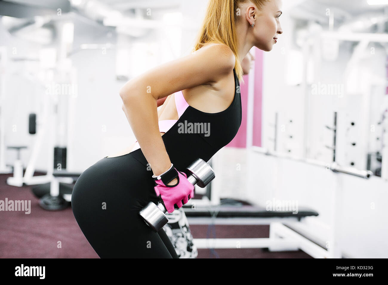 Woman in gym using dumbbells Stock Photo - Alamy