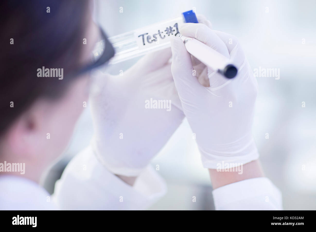 Laboratory worker writing details on test tube, rear view Stock Photo ...