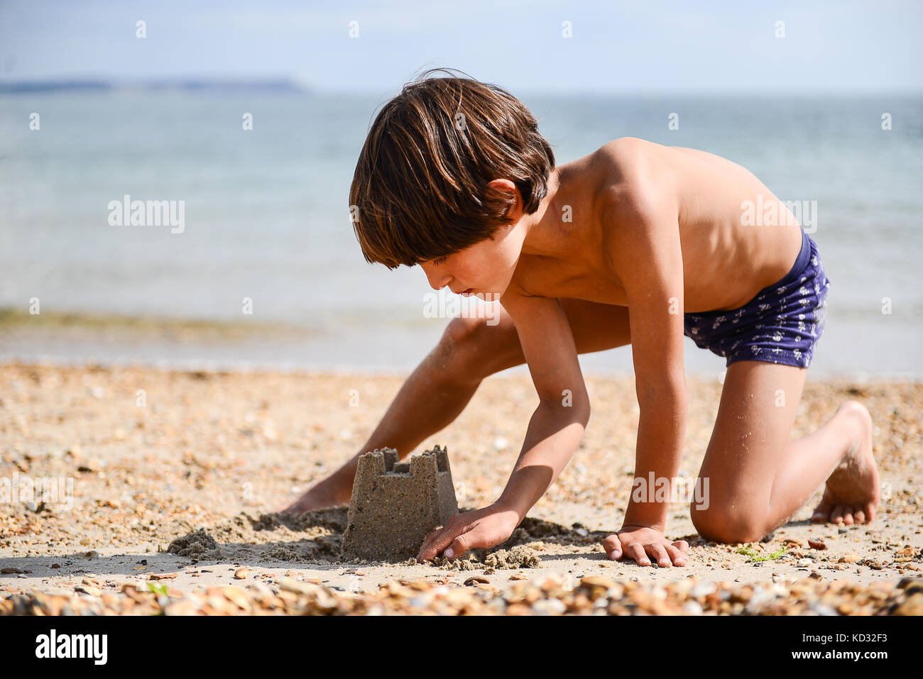Boy building sandcastle on beach hi-res stock photography and images ...