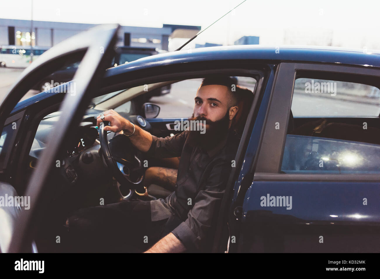 Bearded man in car looking at camera Stock Photo - Alamy