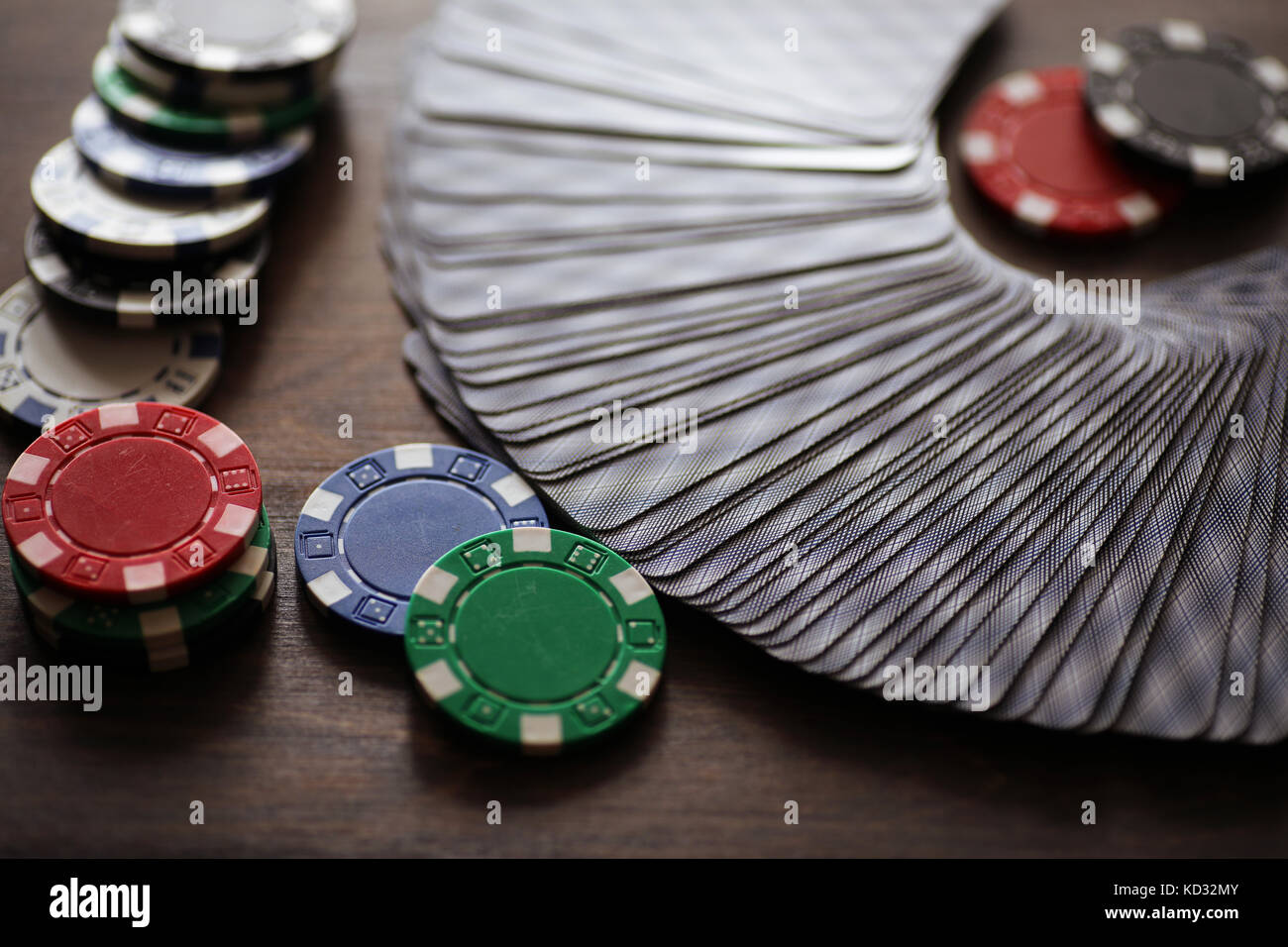 Card game using chips on a wooden table Stock Photo - Alamy