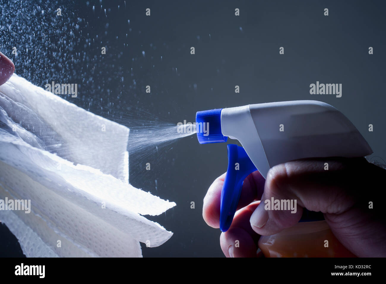 Cropped view of man spraying cleaning product of cloth Stock Photo - Alamy