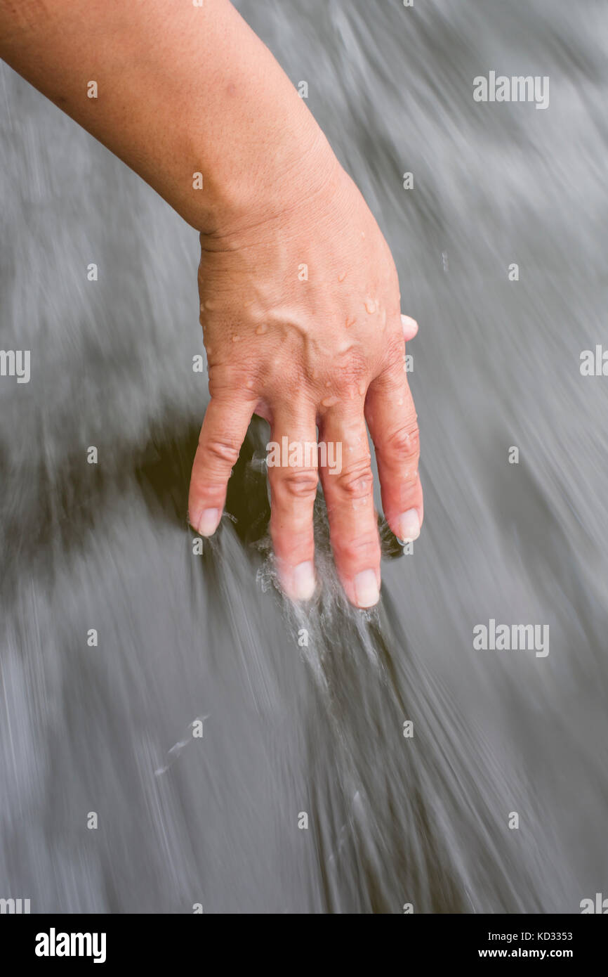 Woman dragging hand in water Stock Photo - Alamy