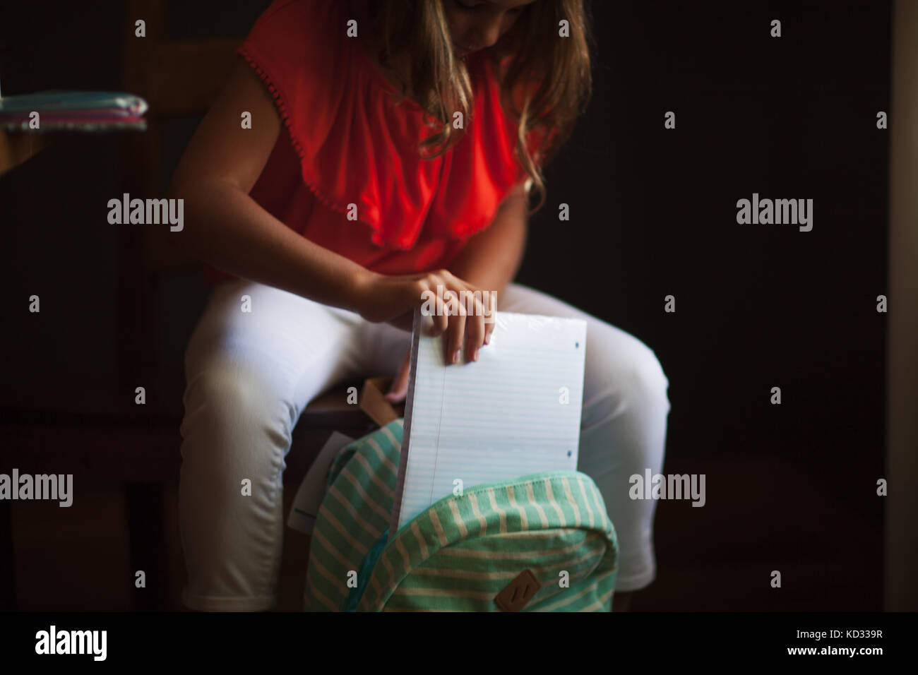 Girl packing backpack with school stationery supplies Stock Photo - Alamy