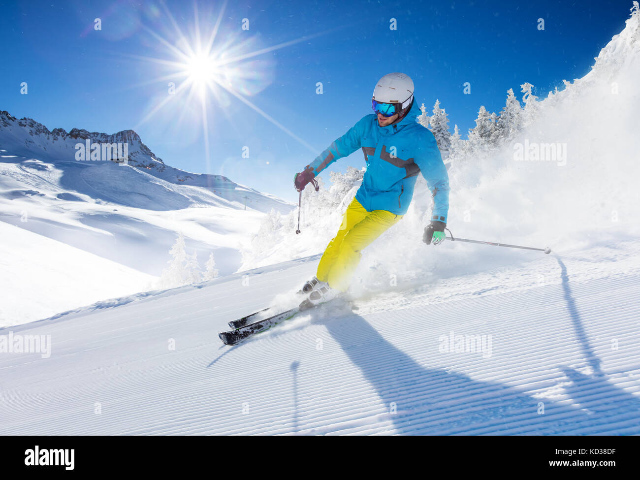 Young man skier running down the slope in Alpine mountains. Winter ...