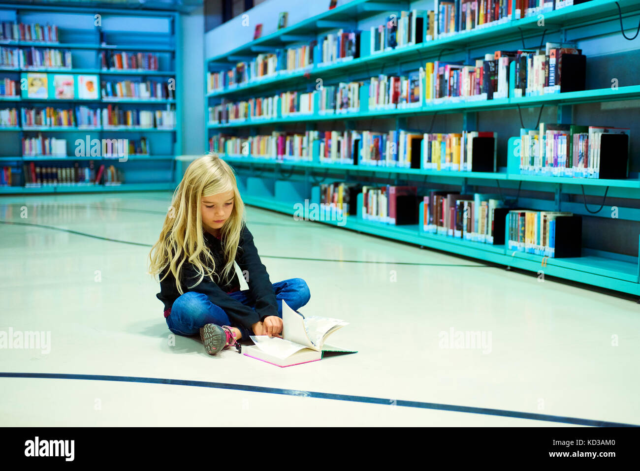 Child girl in public library with books Stock Photo - Alamy