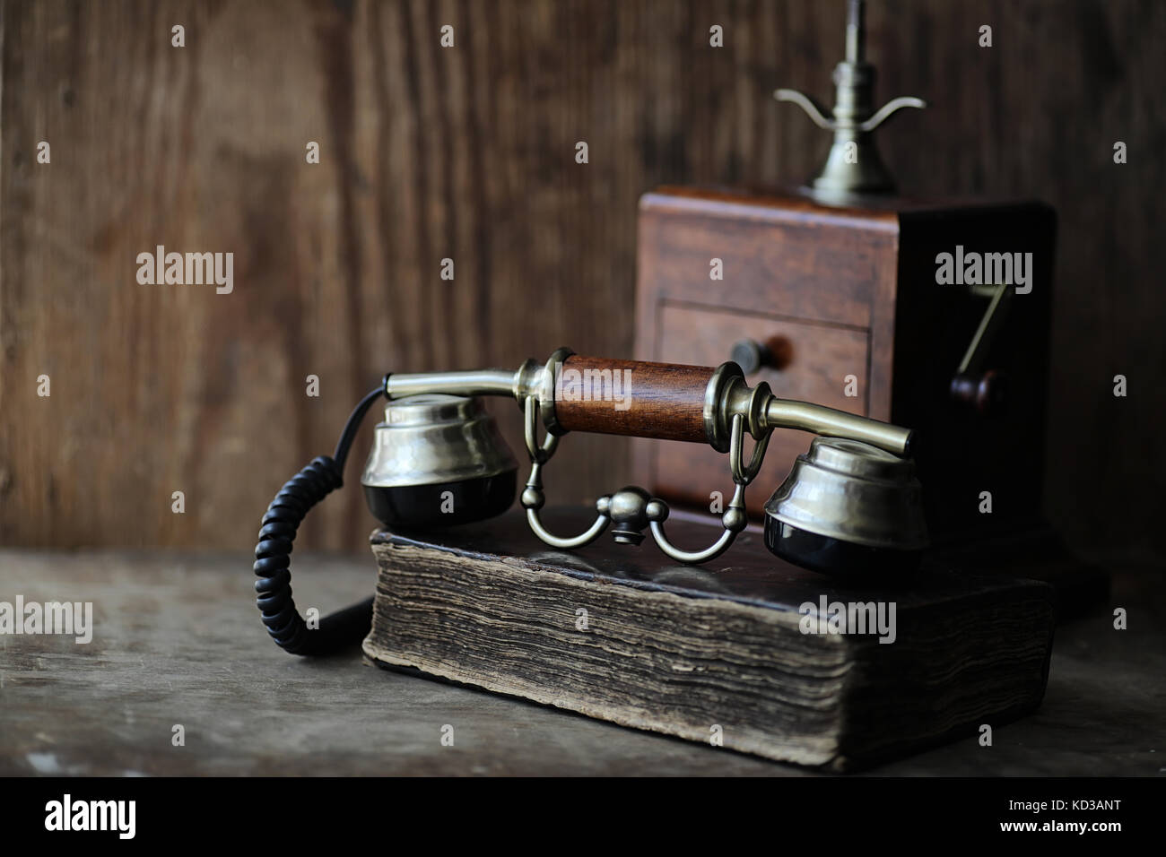 Old telephone and retro book on a wood Stock Photo - Alamy