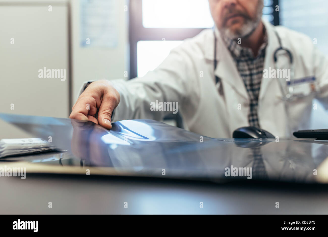 Hand doctor picking a x-ray from his office desk. Male physician ...
