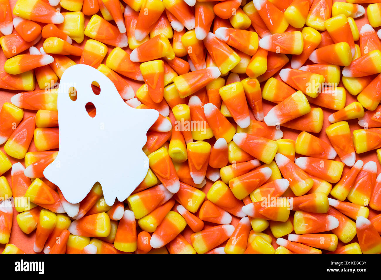 Halloween candy corn background with white ghost Stock Photo - Alamy