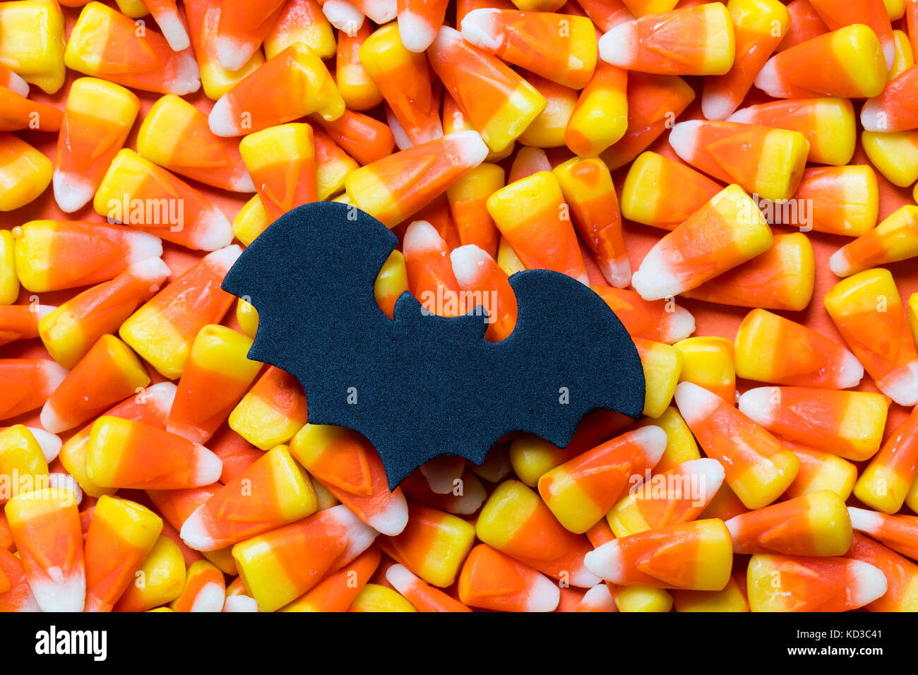 Halloween candy corn background with a black bat Stock Photo - Alamy