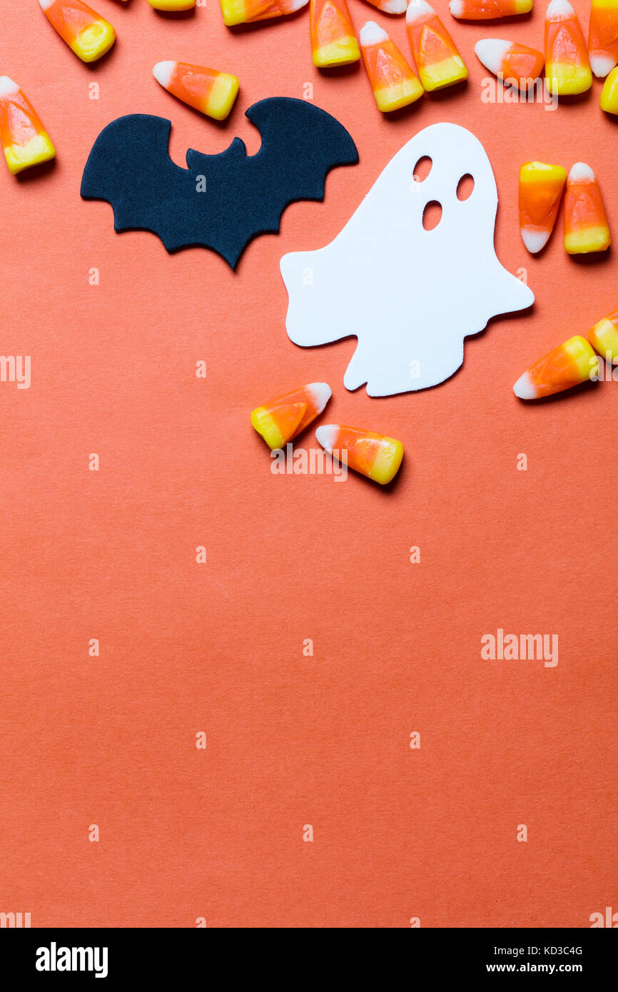 Halloween background with candy corn, ghost and bat Stock Photo - Alamy