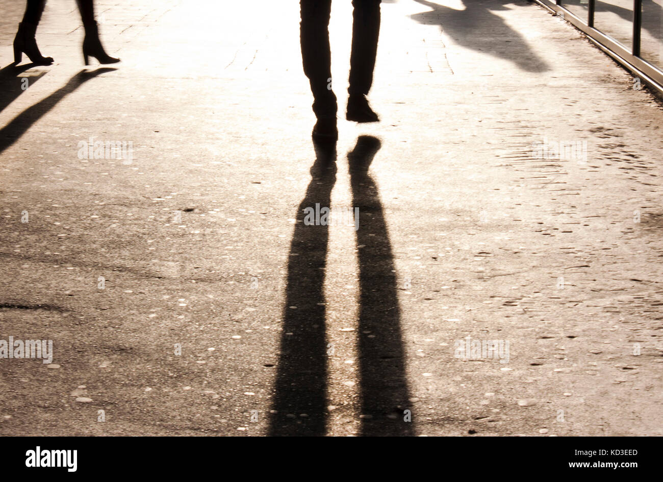 Defocused shadow and silhouette of people legs on city sidewalk Stock ...