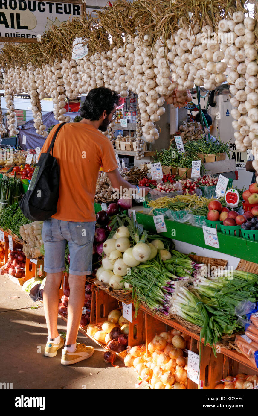 Tall young man shopping at a fruit and vegetable stall in the Jean ...