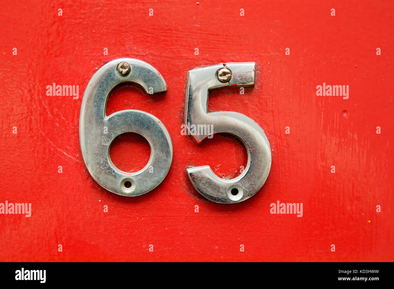 Number 65 in chrome against a red background Stock Photo - Alamy