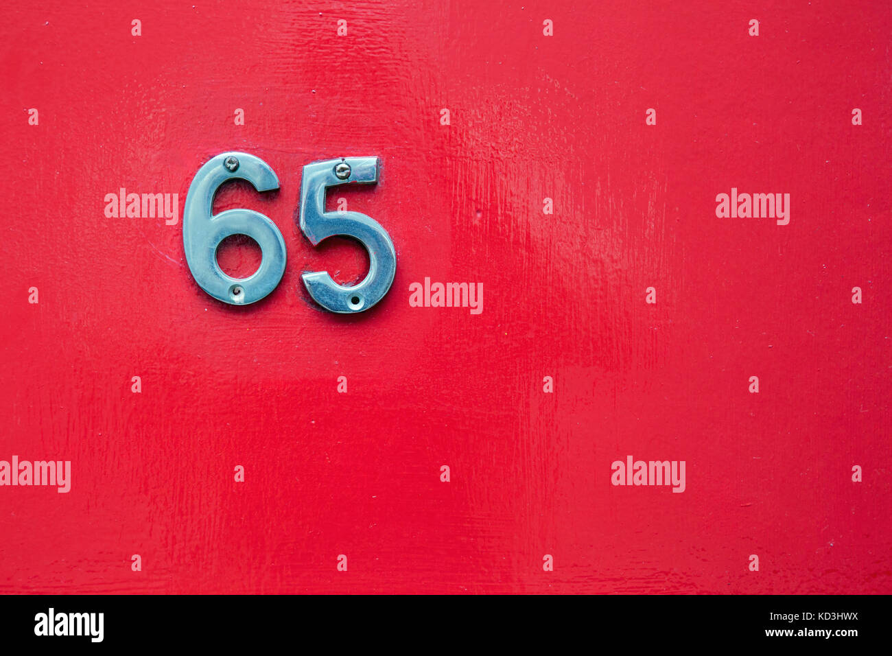 Number 65 in chrome against a red background Stock Photo - Alamy