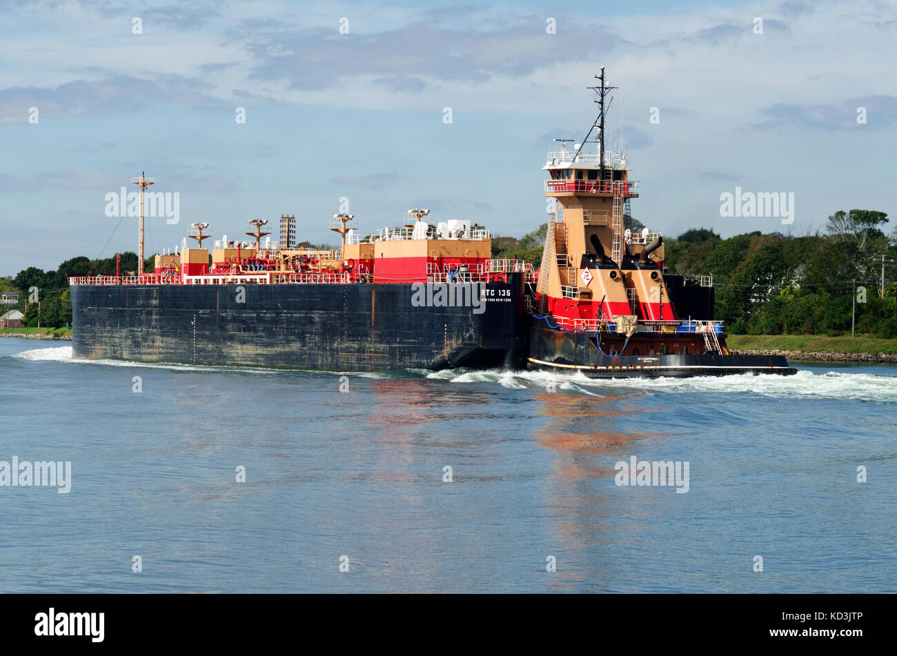 Fuel barge navigating in Cape Cod Canal by being pushed by tugboat, USA ...