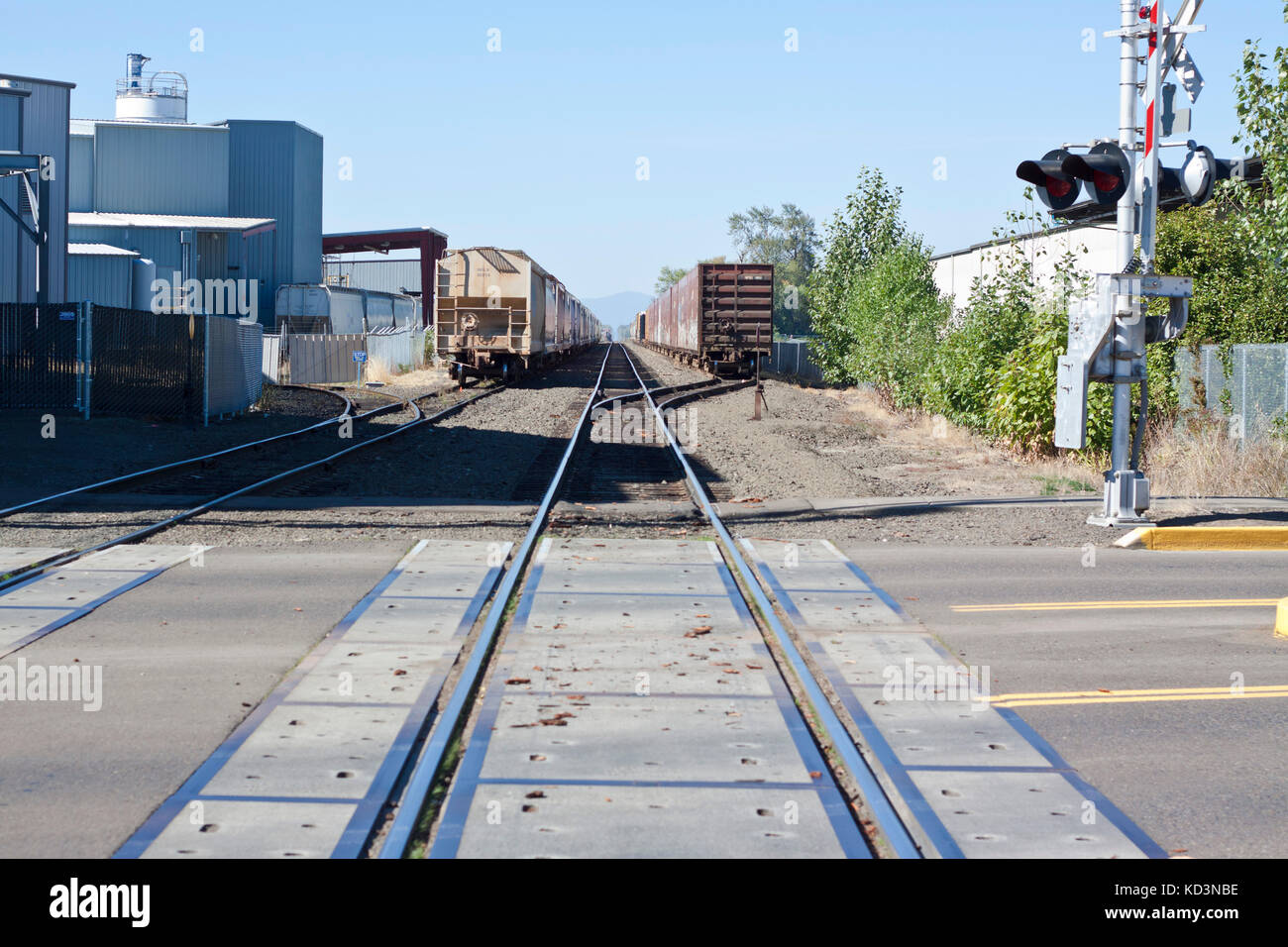 Train tracks through industrial area Stock Photo - Alamy