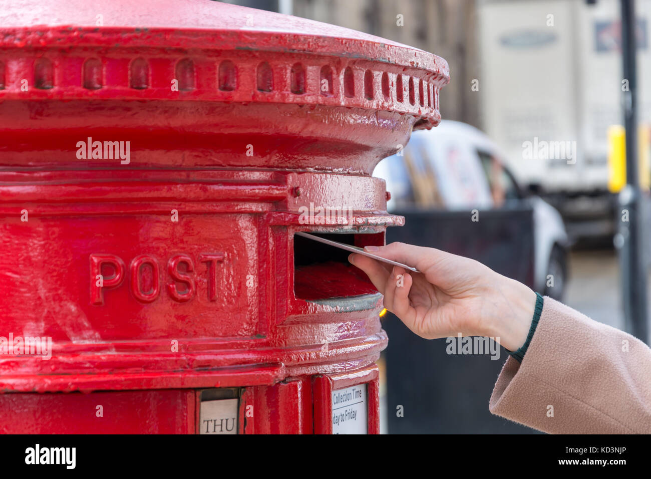 Throwing a letter in a red British post box from the side Stock Photo ...