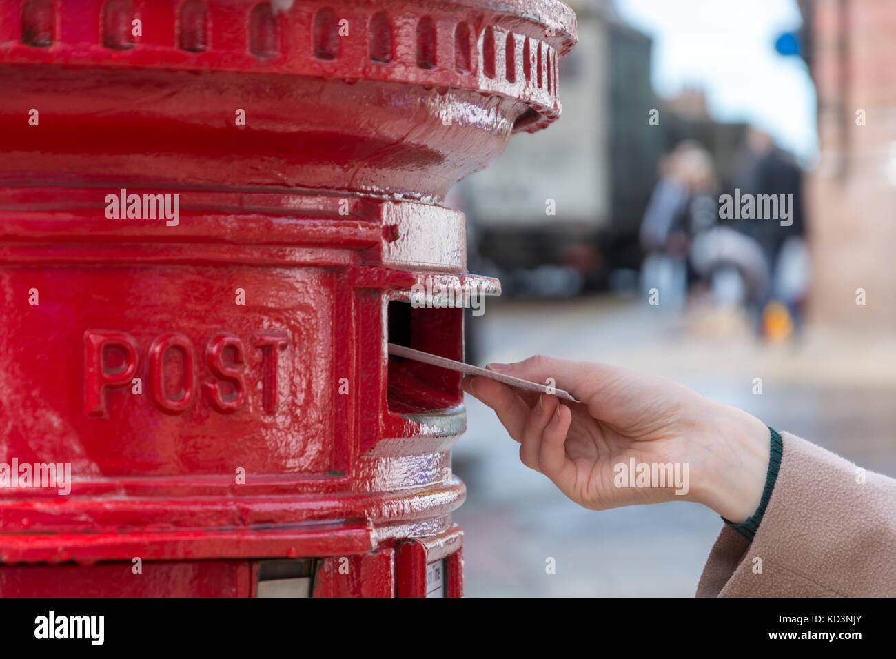 Throwing a letter in a red British post box from the side Stock Photo ...