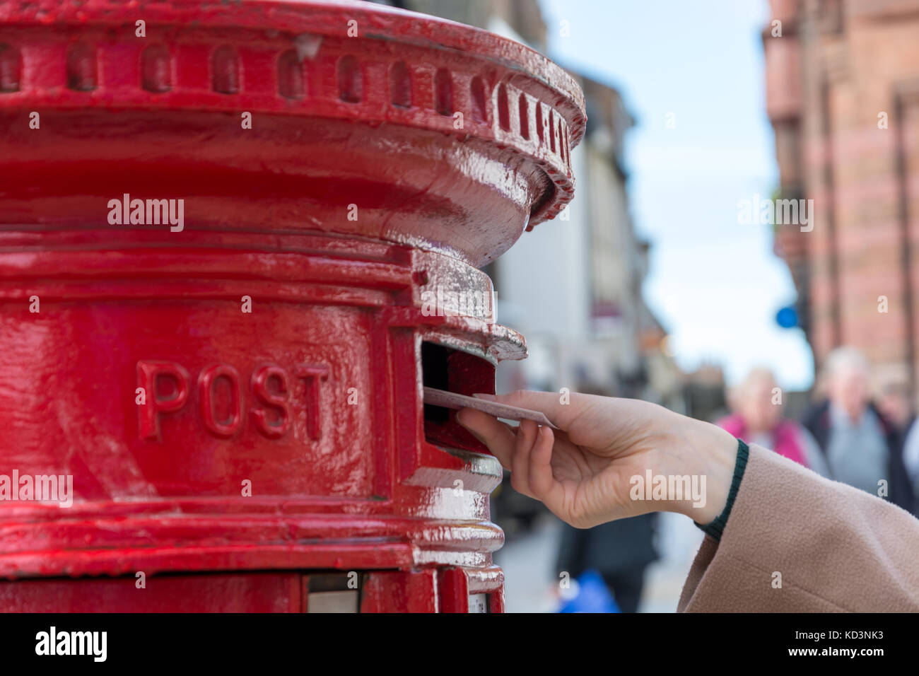 Throwing a letter in a red British post box from the side Stock Photo ...