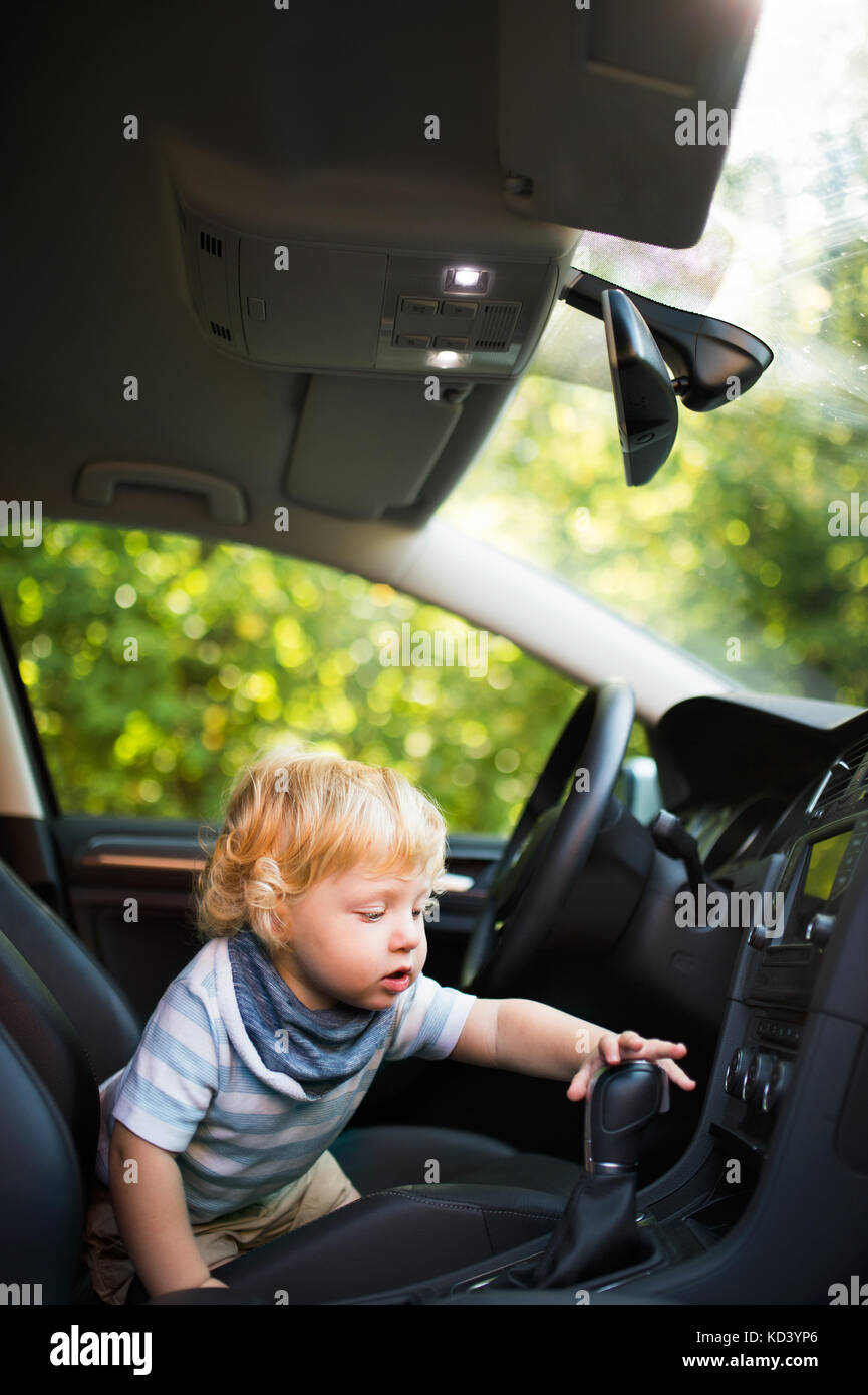 Cute little boy playing in the car, pretending to drive it Stock Photo ...