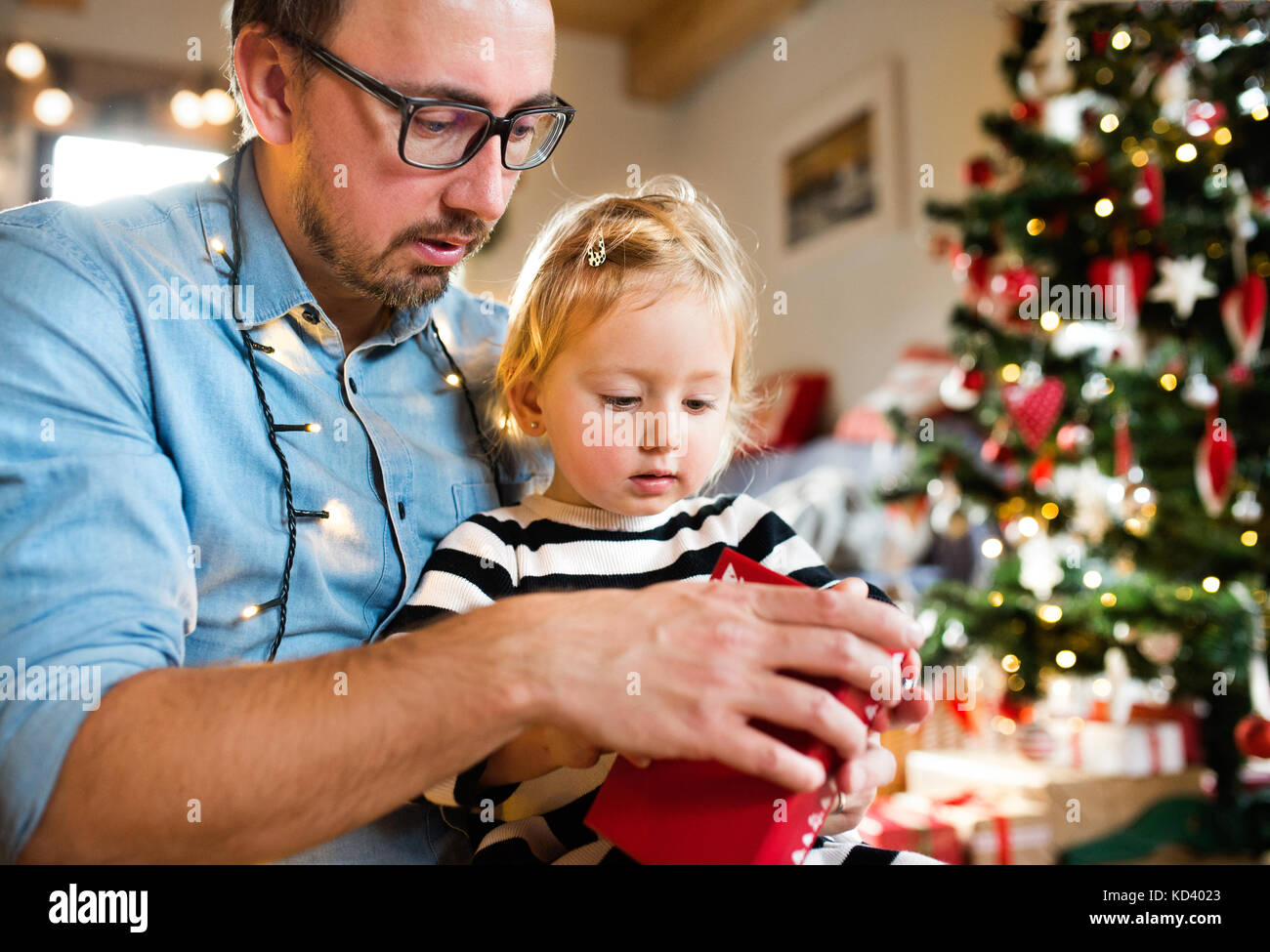 Beautiful little girl with her father opening Christmas present Stock ...