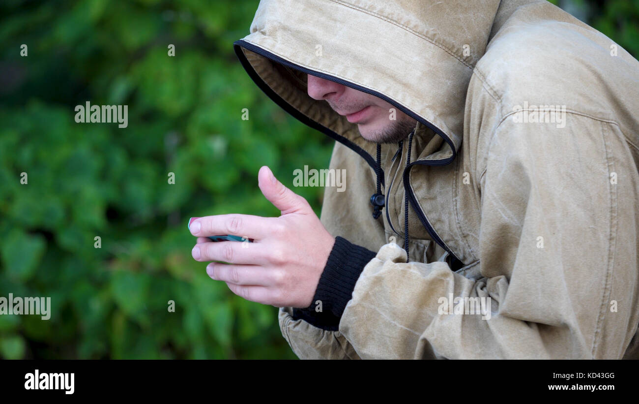 Busy young environmentalist is working on the phone in the woods. Young ...