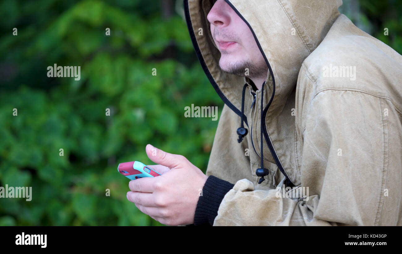 Busy young environmentalist is working on the phone in the woods. Young ...