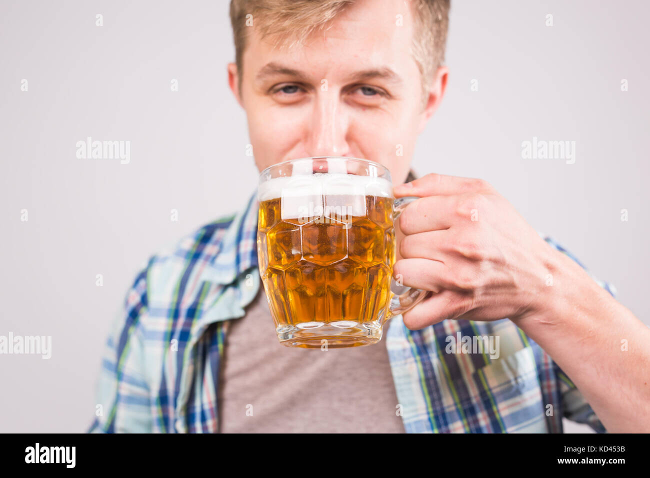 Man drinking beer. Happy young man holding a beer mug Stock Photo - Alamy