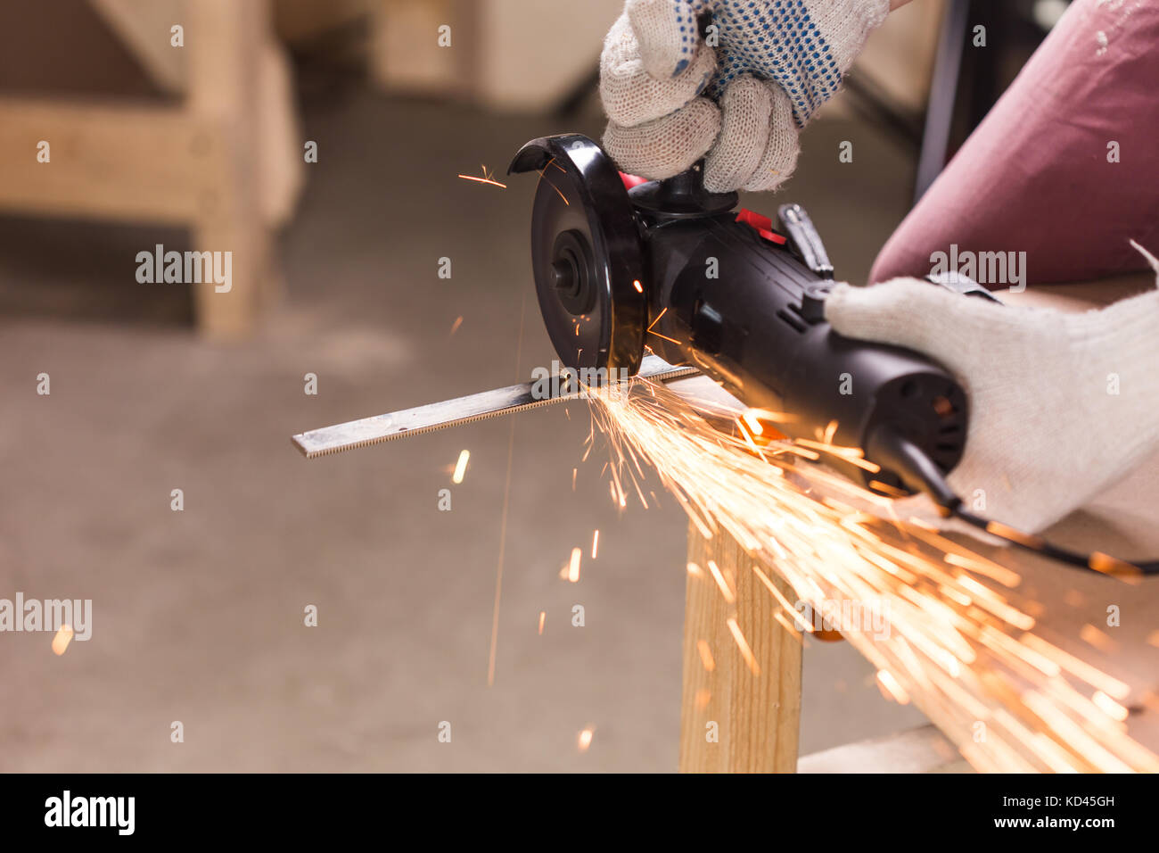 Heavy industry worker cutting steel with angle grinder at car service ...