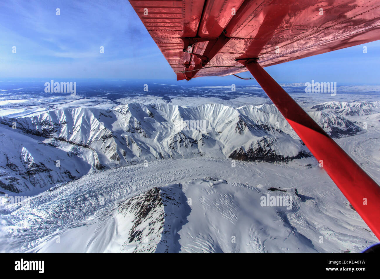 Plane flies over snow caped mountains in Denali Alaska Stock Photo - Alamy