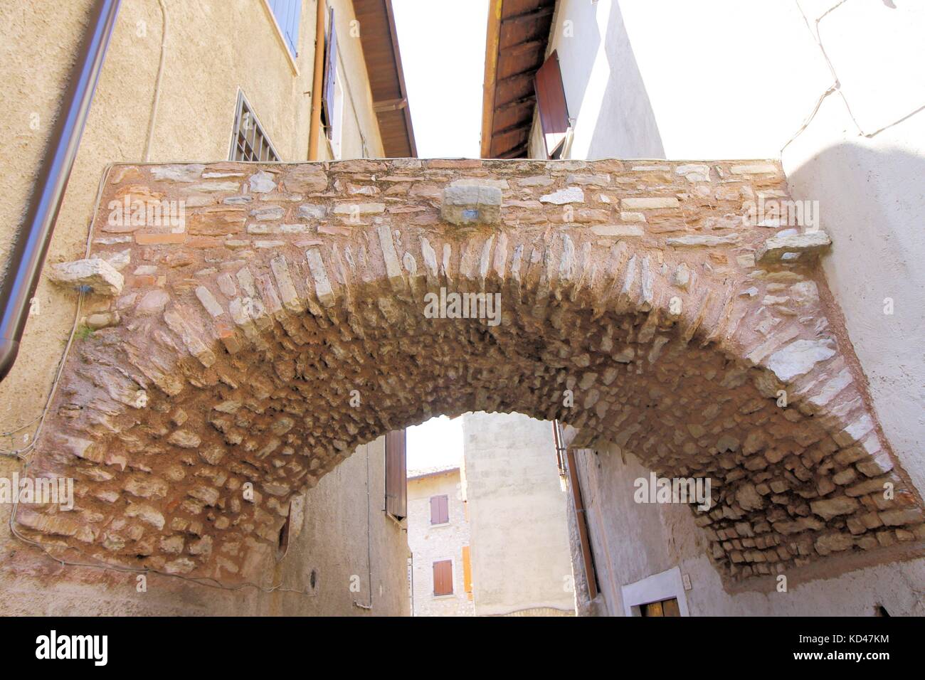 architectural detail of a small bridge between two ancient houses in a ...