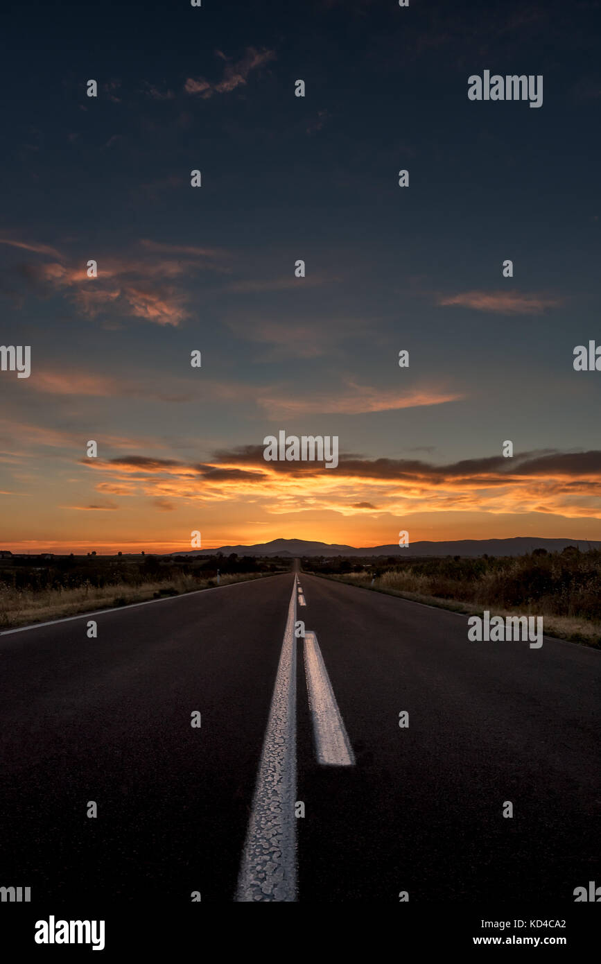 Straight highway road to a dramatic fiery sunset Stock Photo - Alamy