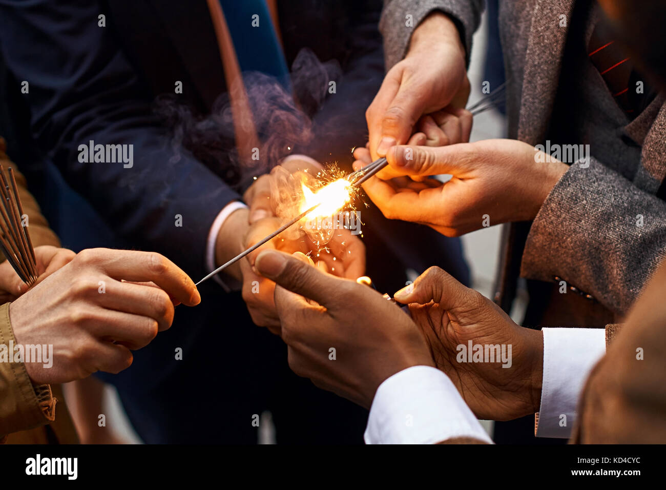 Hands of young people in suits holding burning sparkles fireworks Stock ...