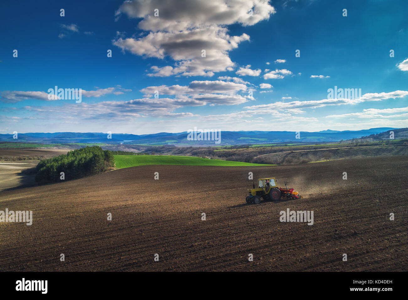 Tractor cultivating field at spring, aerial view Stock Photo - Alamy