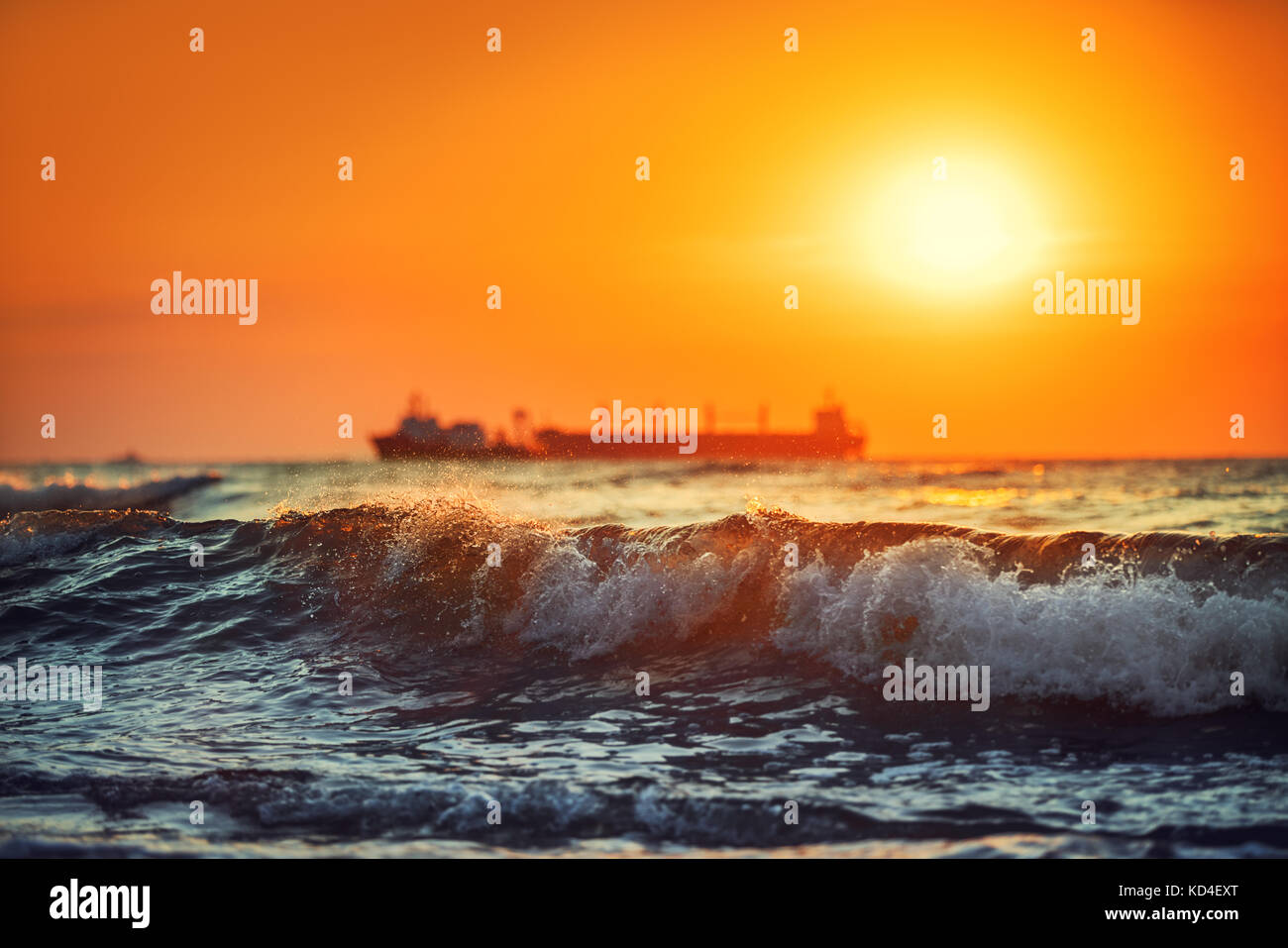 Sun setting at the sea with sailing cargo ship, sunrise. Transportation ...