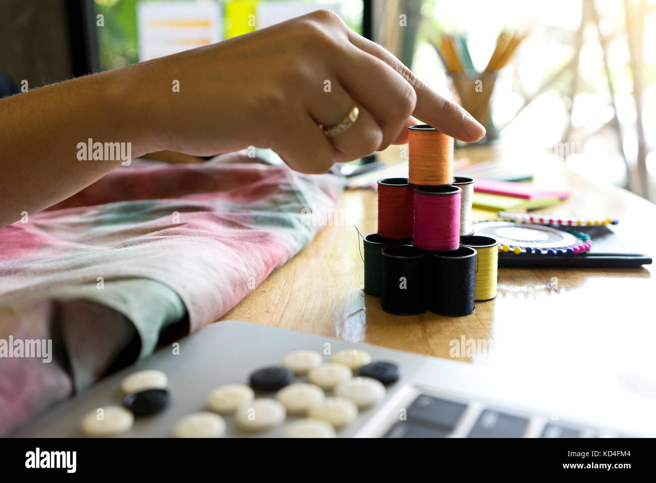 young fashion designer work with fabric cloth on the wood table Stock ...