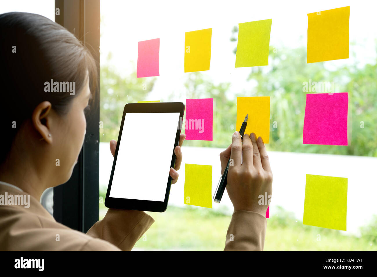 Businesswoman use tablet and looking to Note paper reminder schedule ...