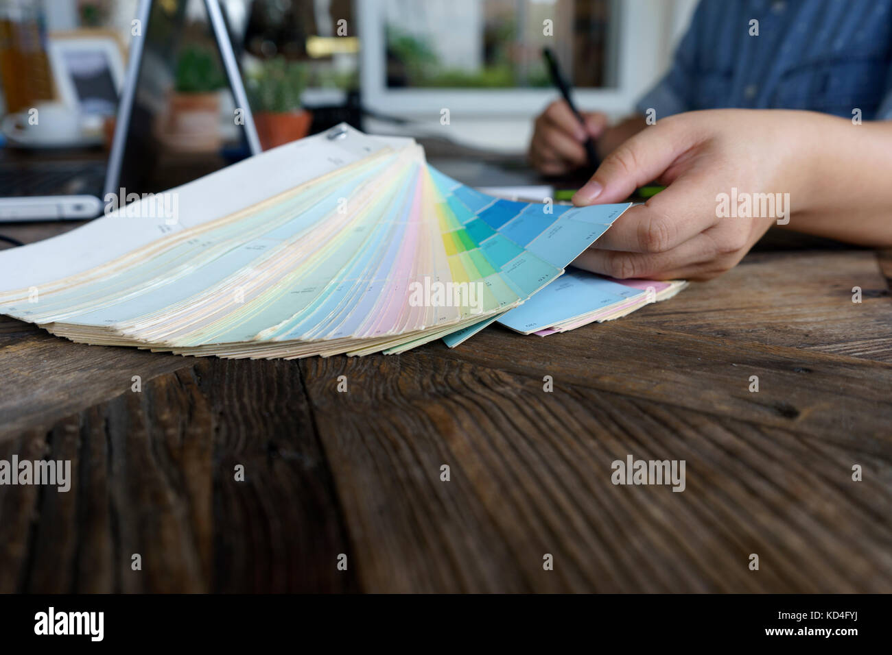 Graphic designer working with computer and color tone paper for choice ...