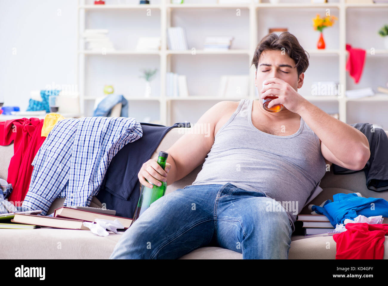 Young man student drunk drinking alcohol in a messy room Stock Photo ...