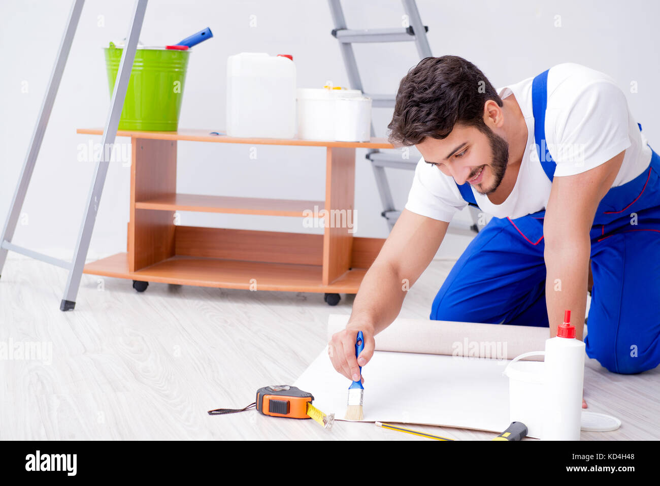 Repairman doing renovation repair in the house with paper wallpaper ...