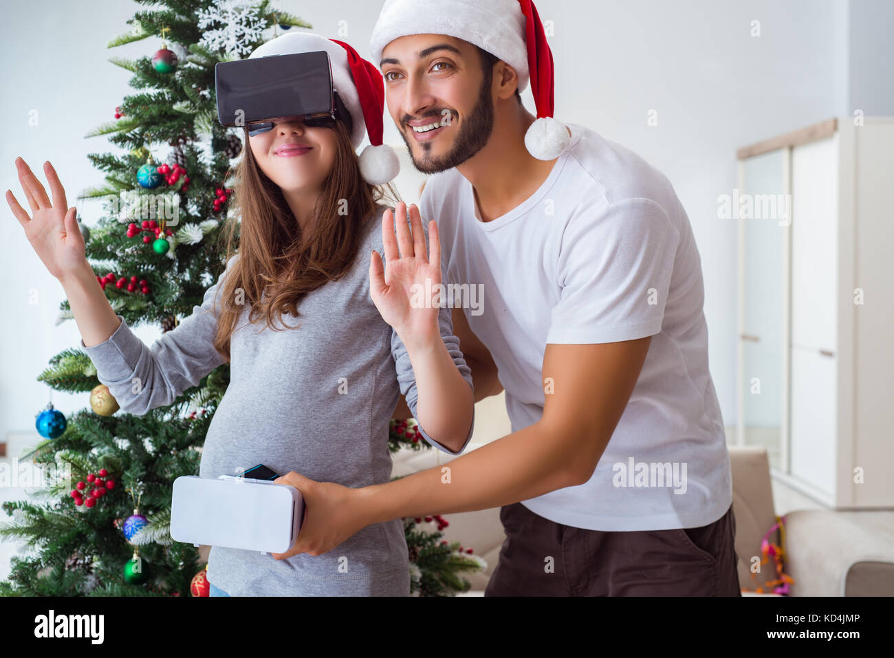 Young family expecting child baby wearing virtual reality VR glasses ...
