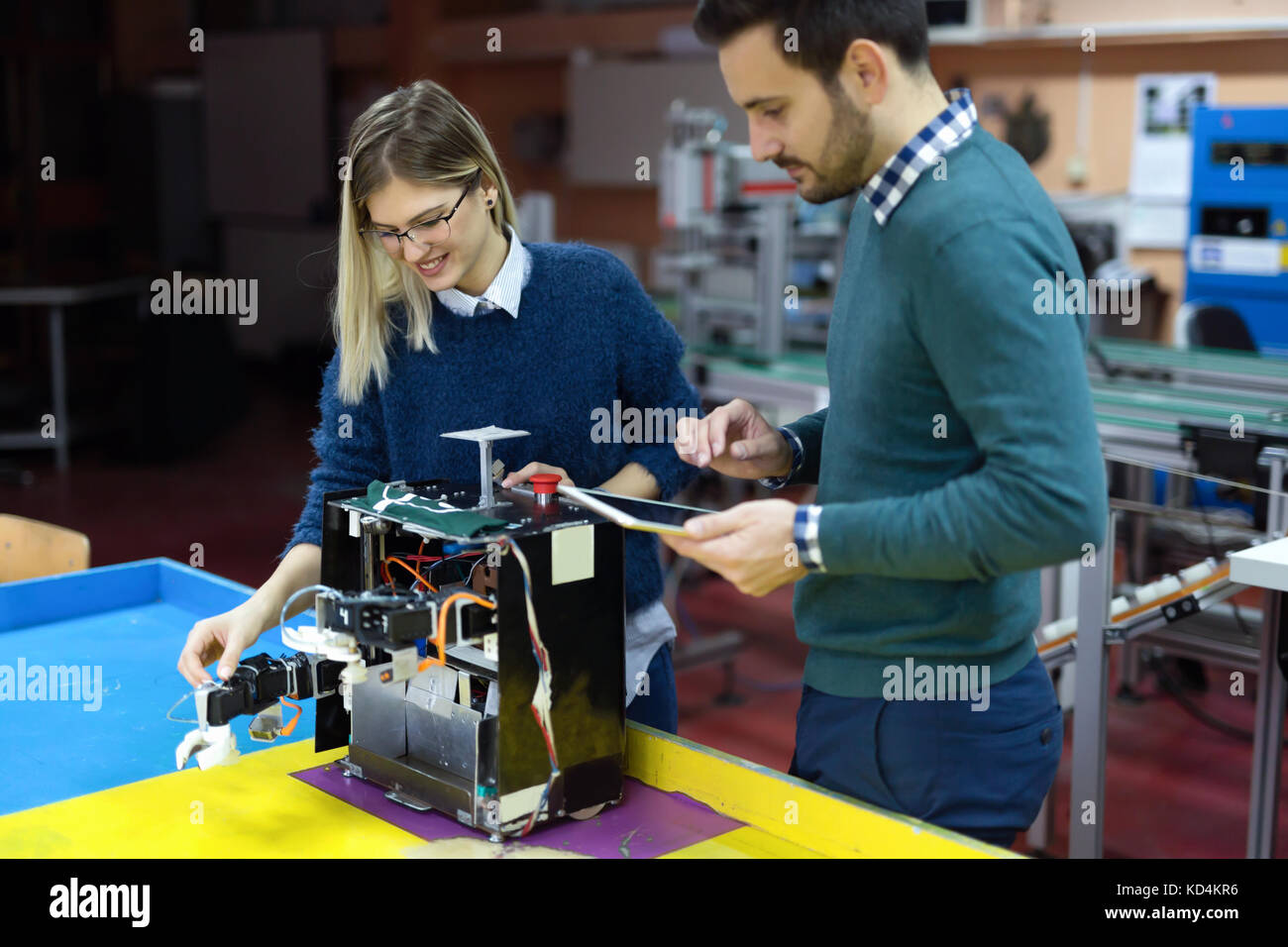 Young students of robotics preparing robot for testing Stock Photo - Alamy