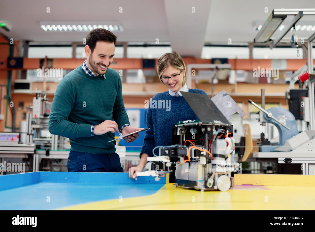 Young students of robotics preparing robot for testing Stock Photo - Alamy