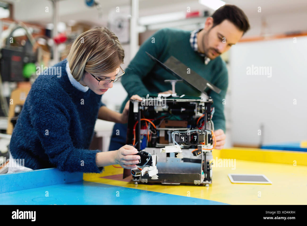 Young students of robotics preparing robot for testing Stock Photo - Alamy