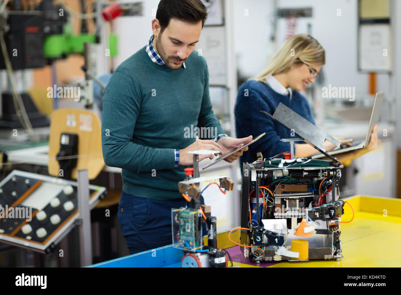 Young students of robotics preparing robot for testing Stock Photo - Alamy