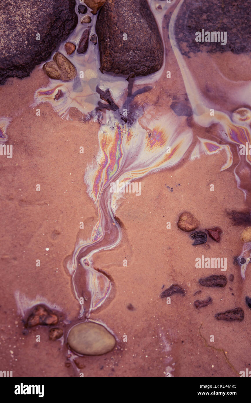 Colorful patterns of oil in the beach sand. Pollution patterns on the ...
