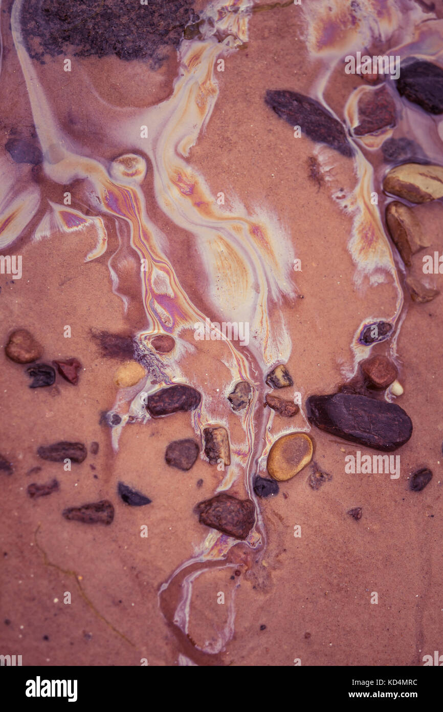 Colorful patterns of oil in the beach sand. Pollution patterns on the ...