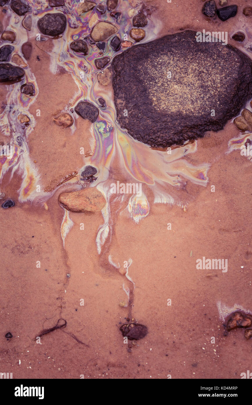 Colorful patterns of oil in the beach sand. Pollution patterns on the ...