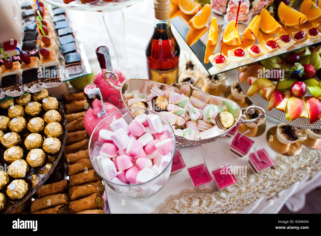 Variety of sweet desserts with fruits and alcohol drinks on the wedding ...